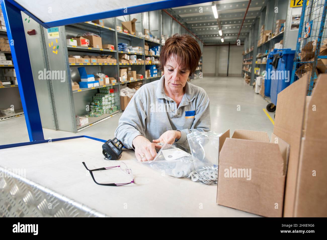 Worker sorting and counting out an order Stock Photo - Alamy
