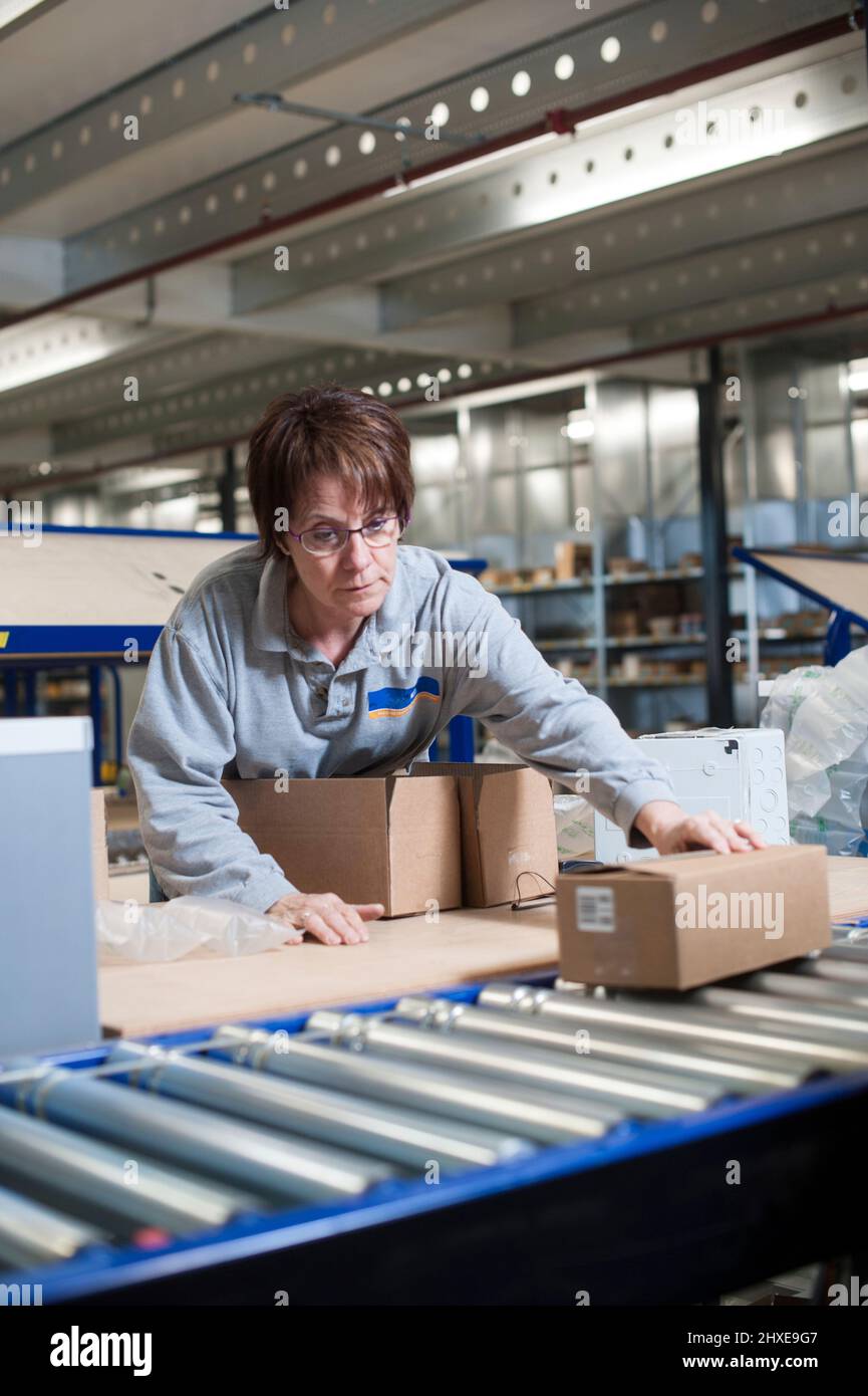 Worker packaging a customer's order in a warehouse Stock Photo - Alamy