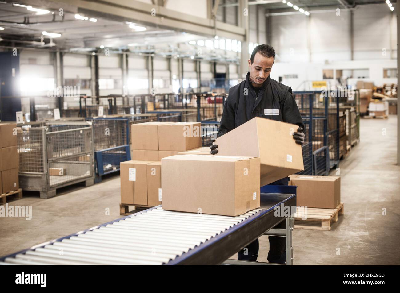 Distribution centre worker sorting packages Stock Photo - Alamy