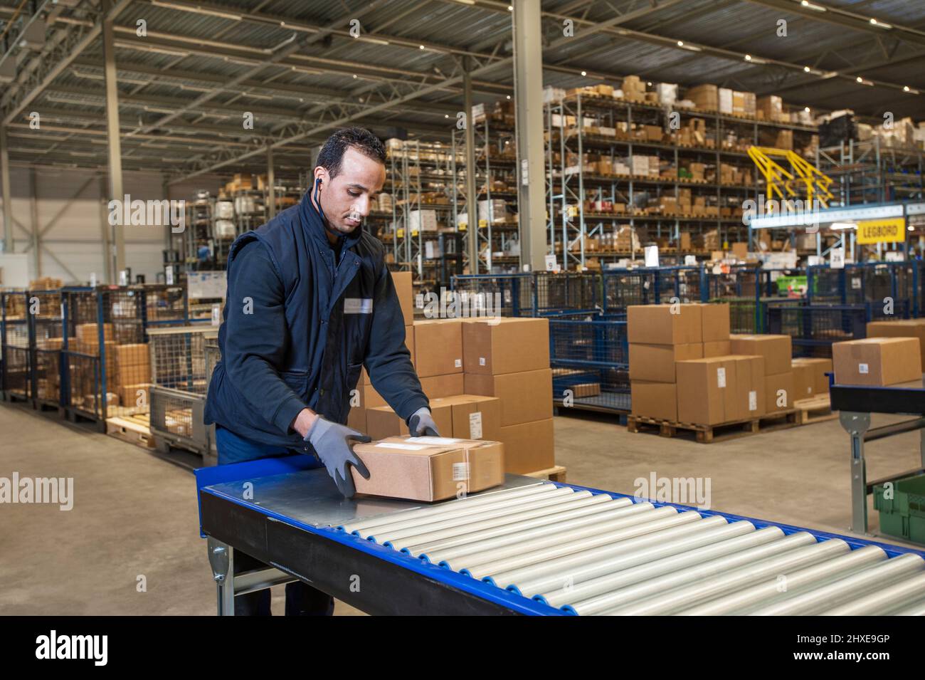Distribution centre worker sorting packages Stock Photo - Alamy