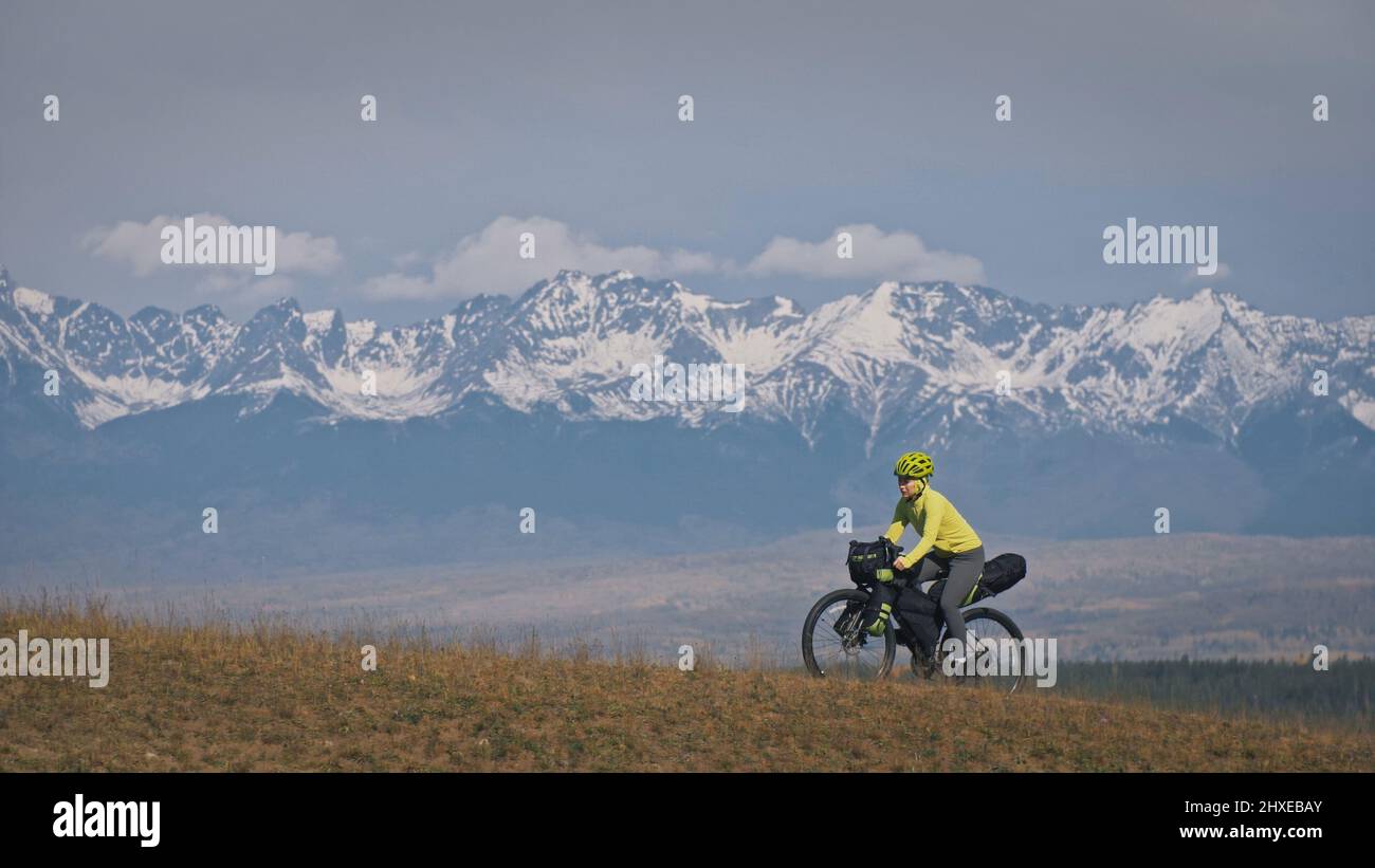 The woman travel on mixed terrain cycle touring with bikepacking. The ...