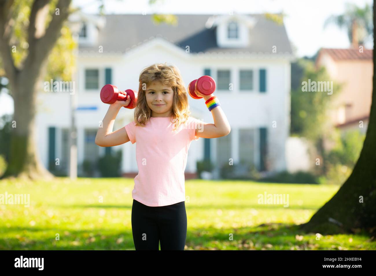 Child boy working out with dumbbells on park background. Kids sport ...