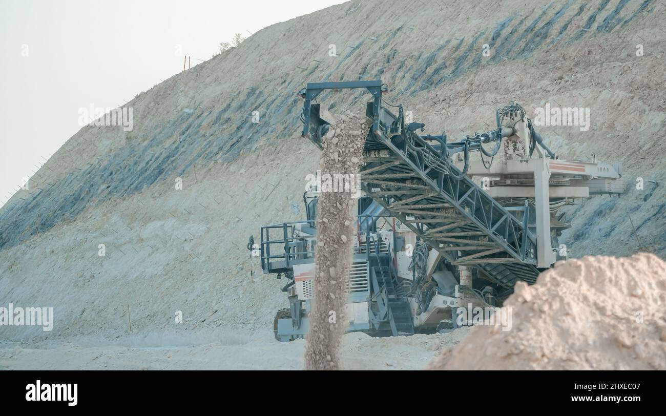 Earth mover cleans up soil for road renewal. Heavy duty mining machine ...