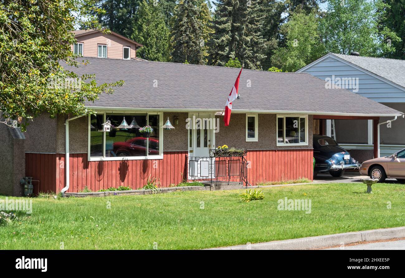 Average residential house with canadian flag and green lawn in front ...