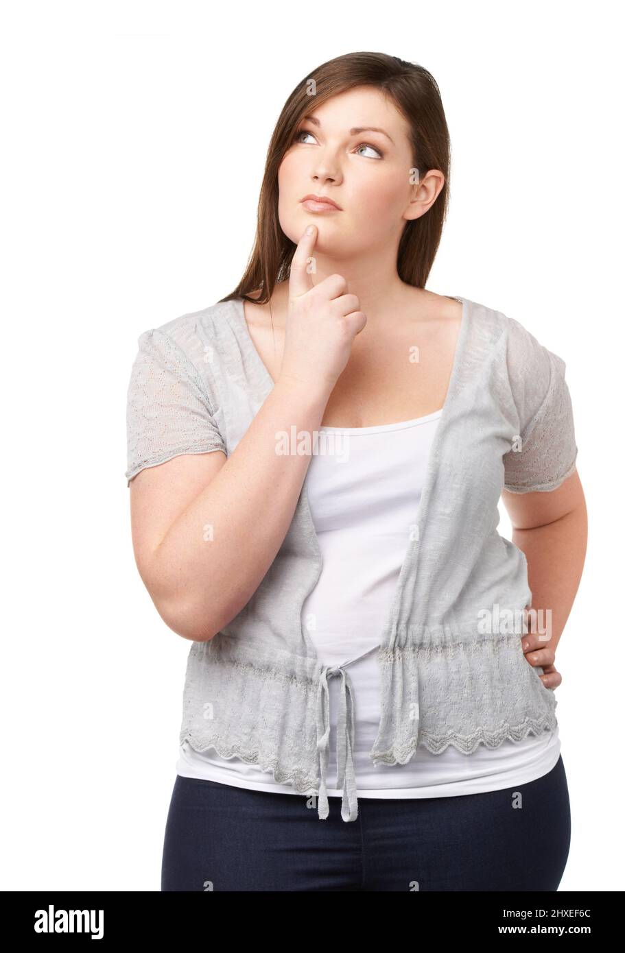 Making choices. A full-figured young woman looking away thoughtfully ...