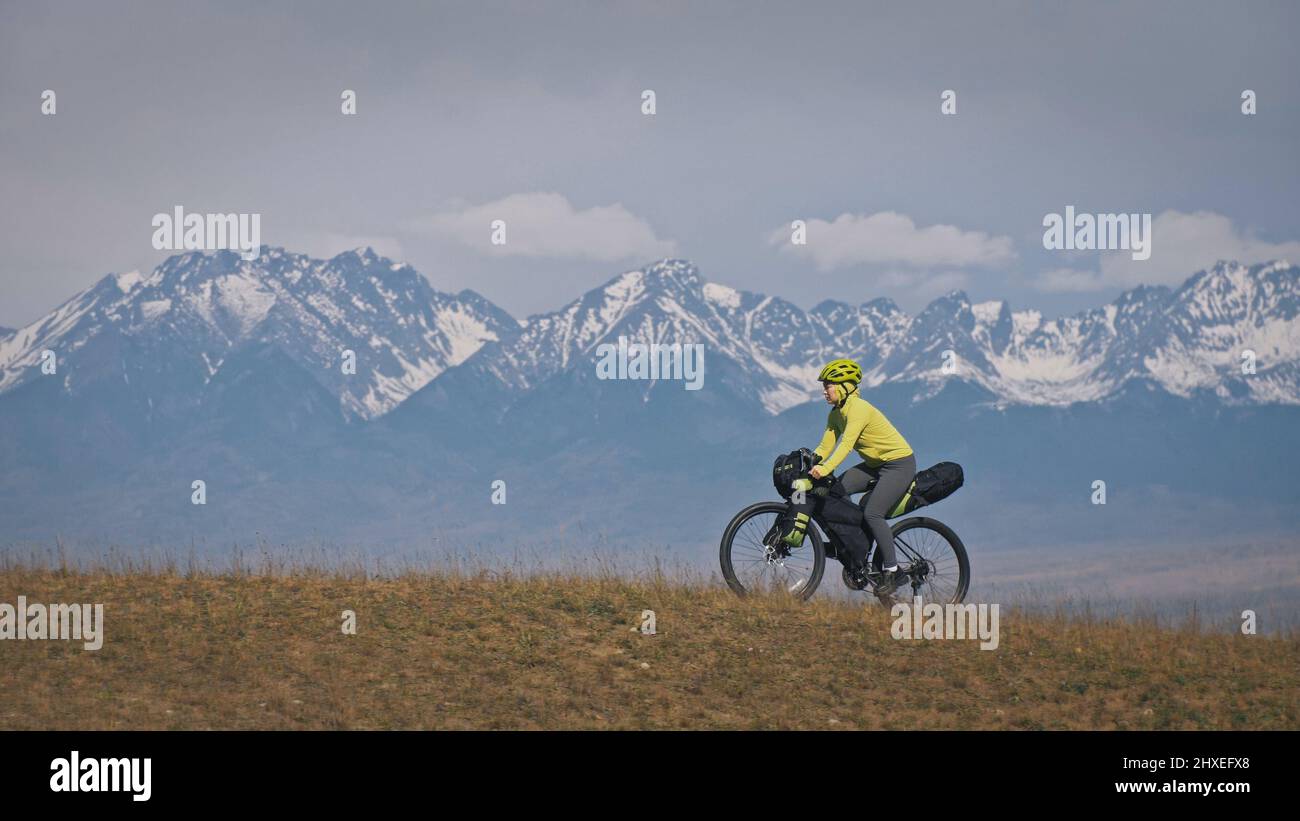The woman travel on mixed terrain cycle touring with bikepacking. The ...
