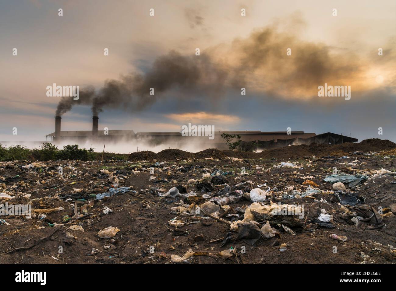 Garbage in front of Smokestack Factory, industry and pollution concept ...
