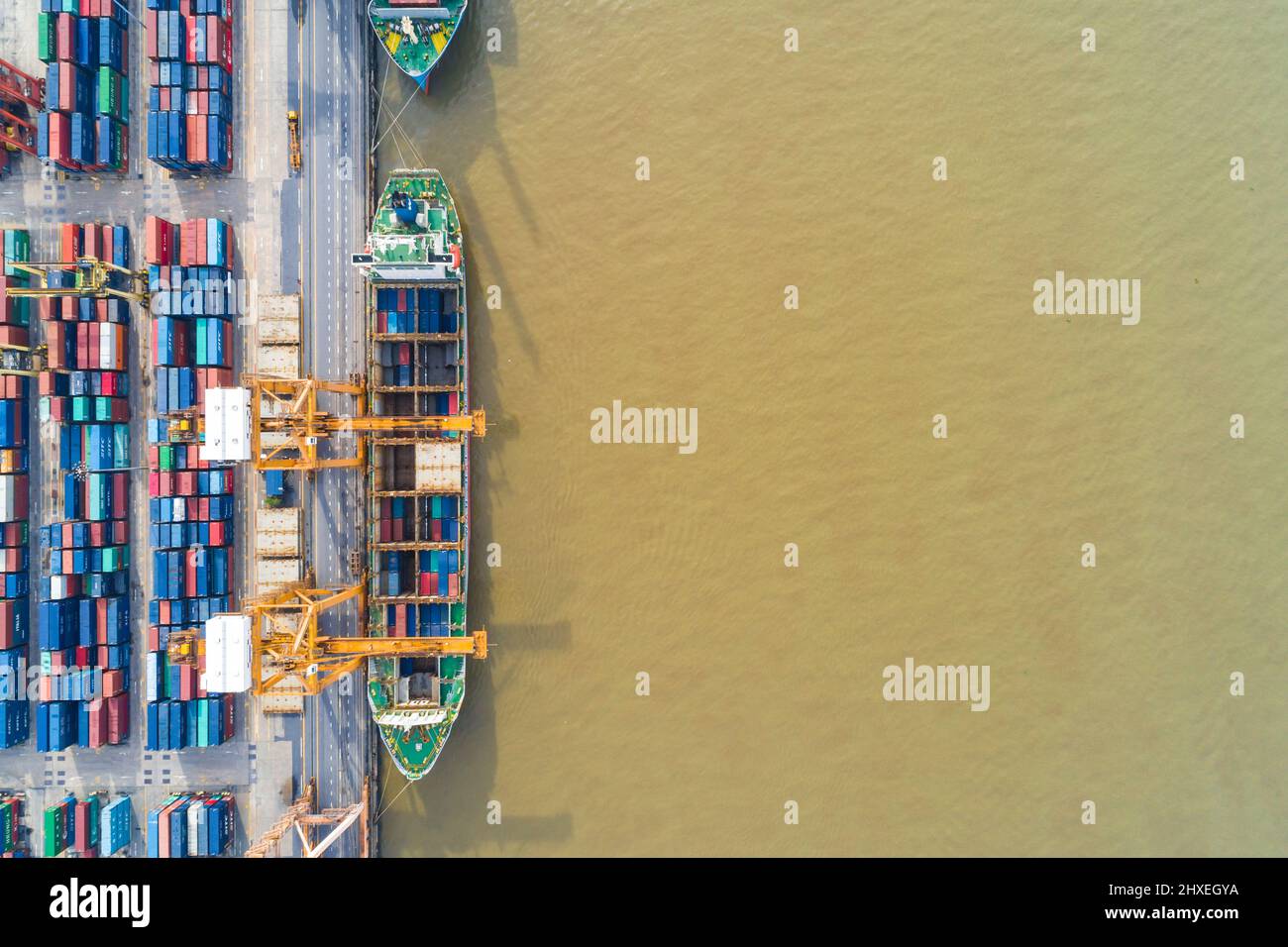 Container cargo ship with working crane bridge in shipping import ...