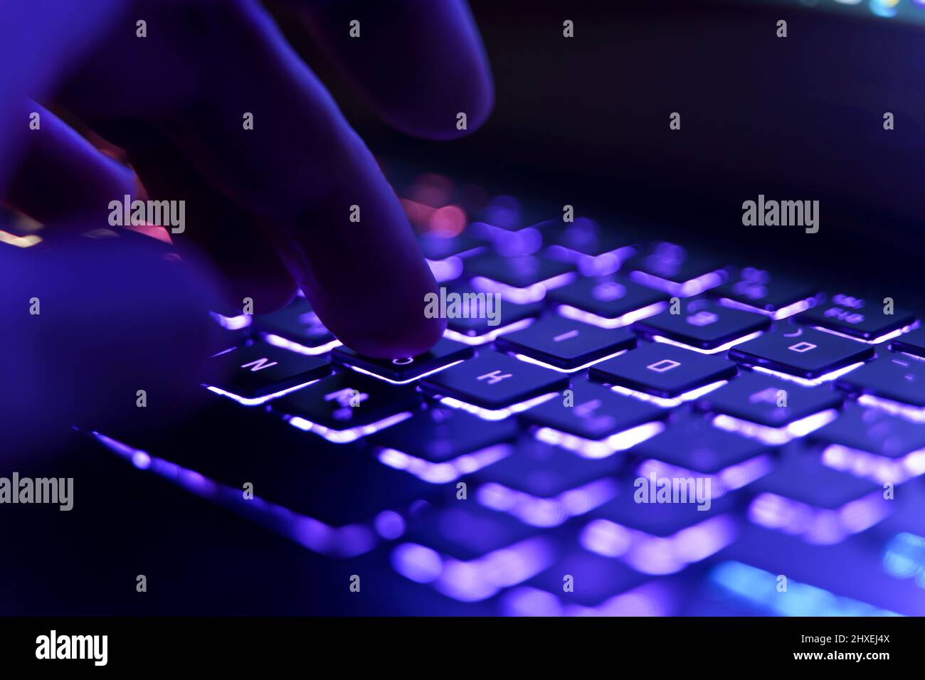 Working on a neon computer keyboard with colored backlighting. Computer ...