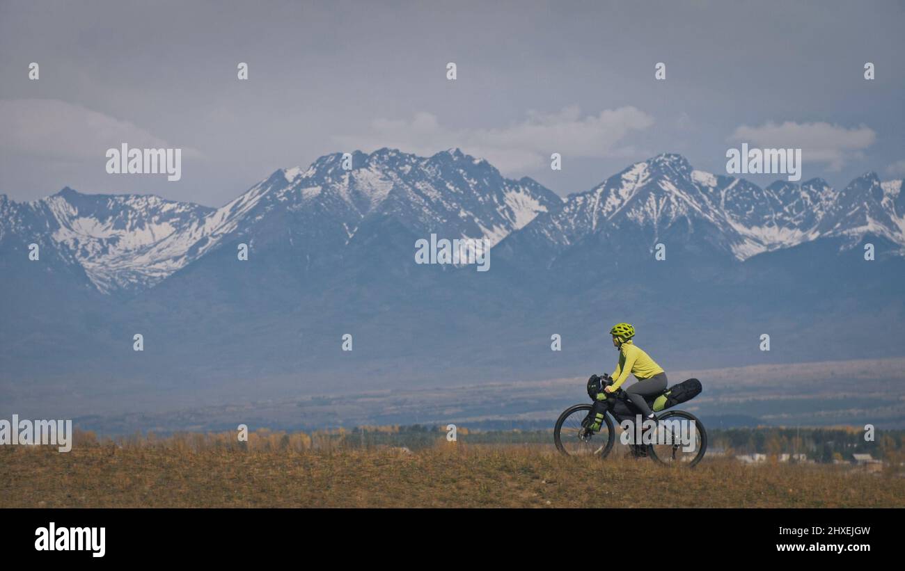 The woman travel on mixed terrain cycle touring with bikepacking. The ...