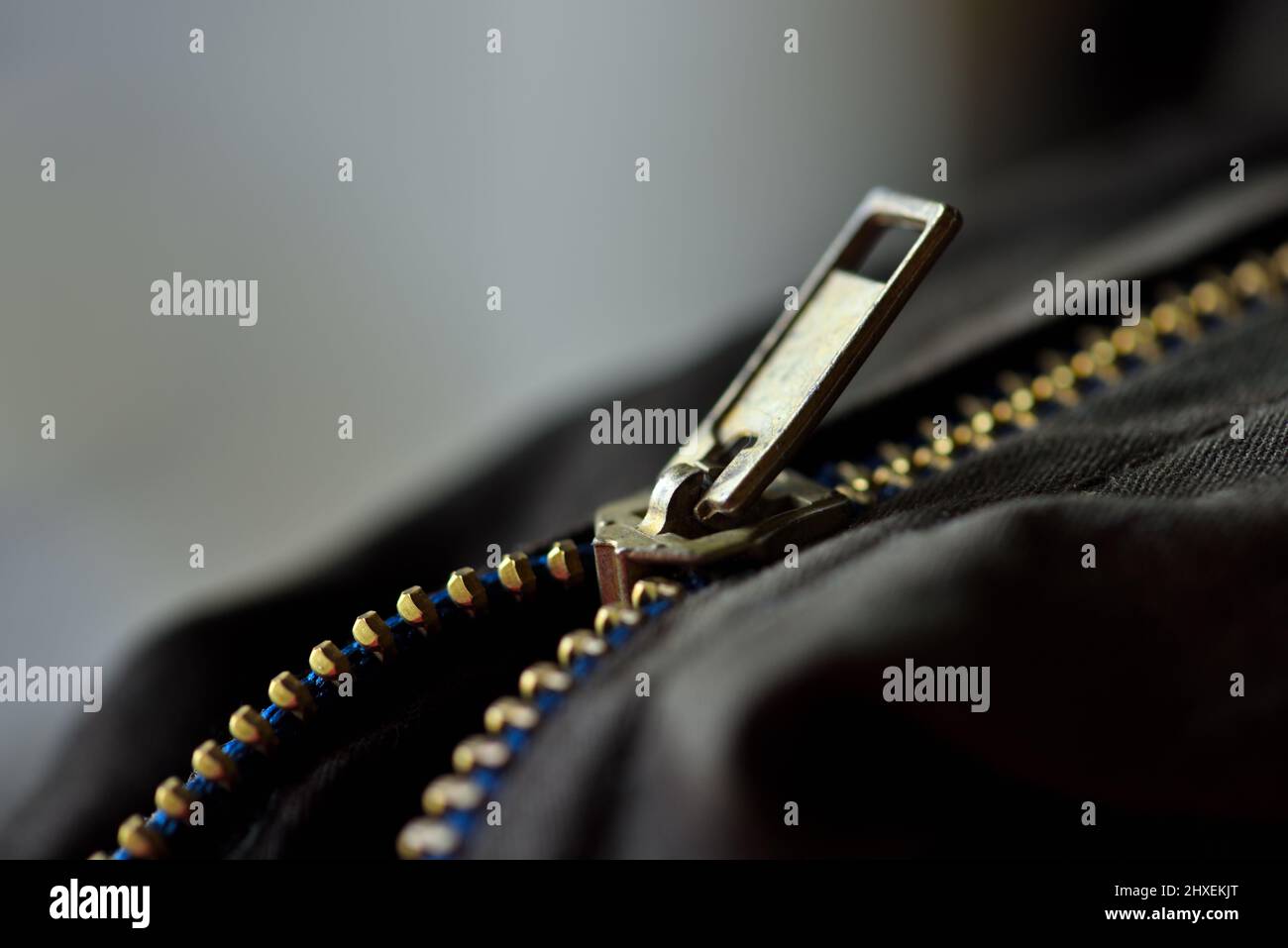 Metal zip on a gray brown fabric stock Stock Photo - Alamy