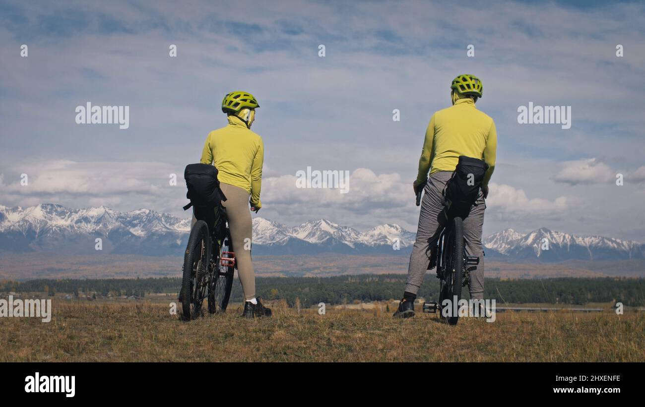 The man and woman travel on mixed terrain cycle touring with ...