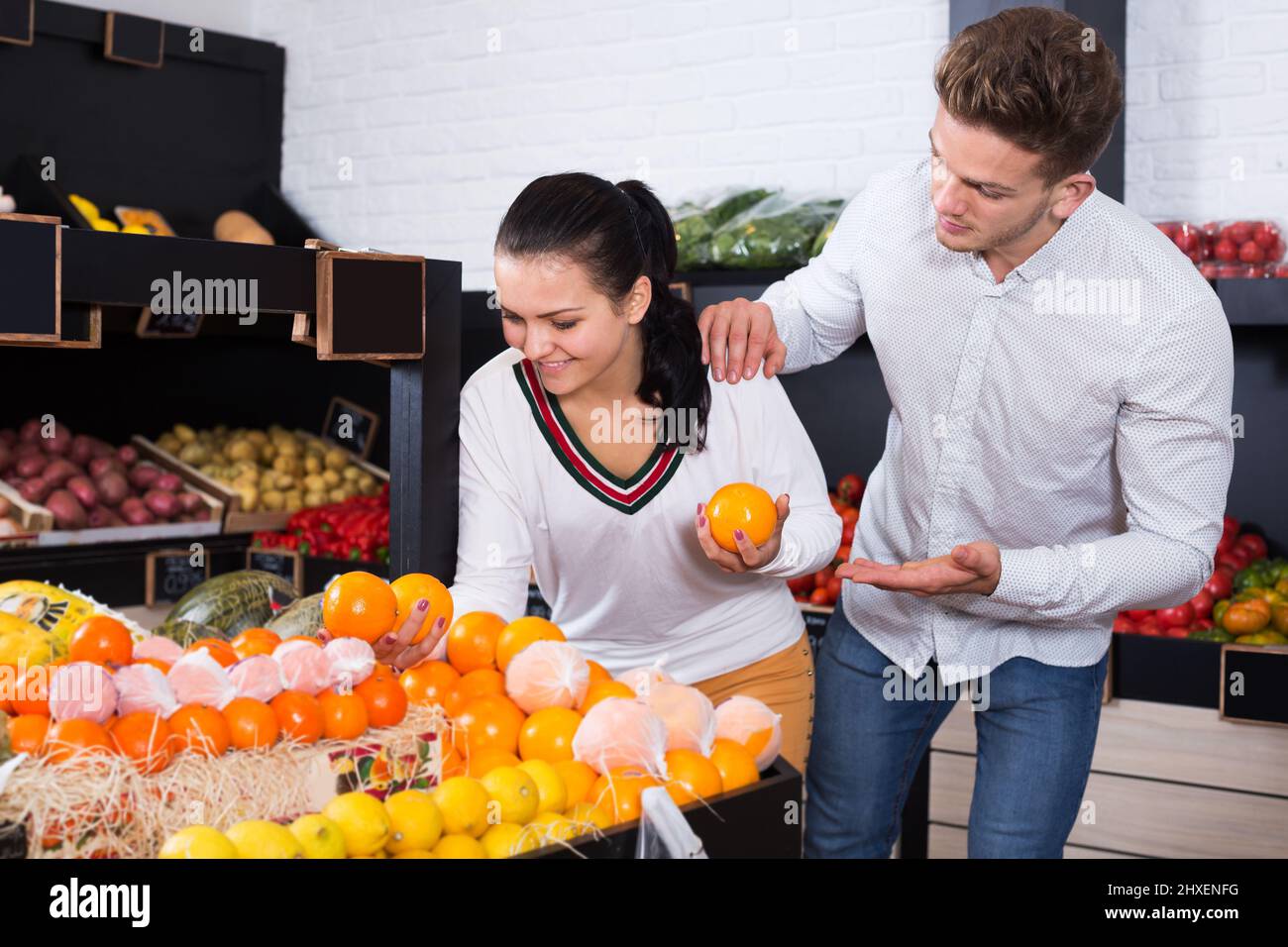 Young glad couple choosing fruits in grocery shop Stock Photo - Alamy