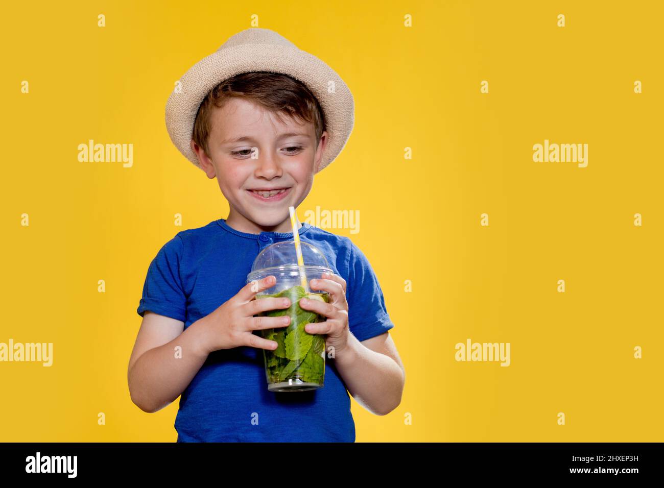 Cute boy Drink Mojito cocktail From Plastic Cup Over Yellow Studio ...