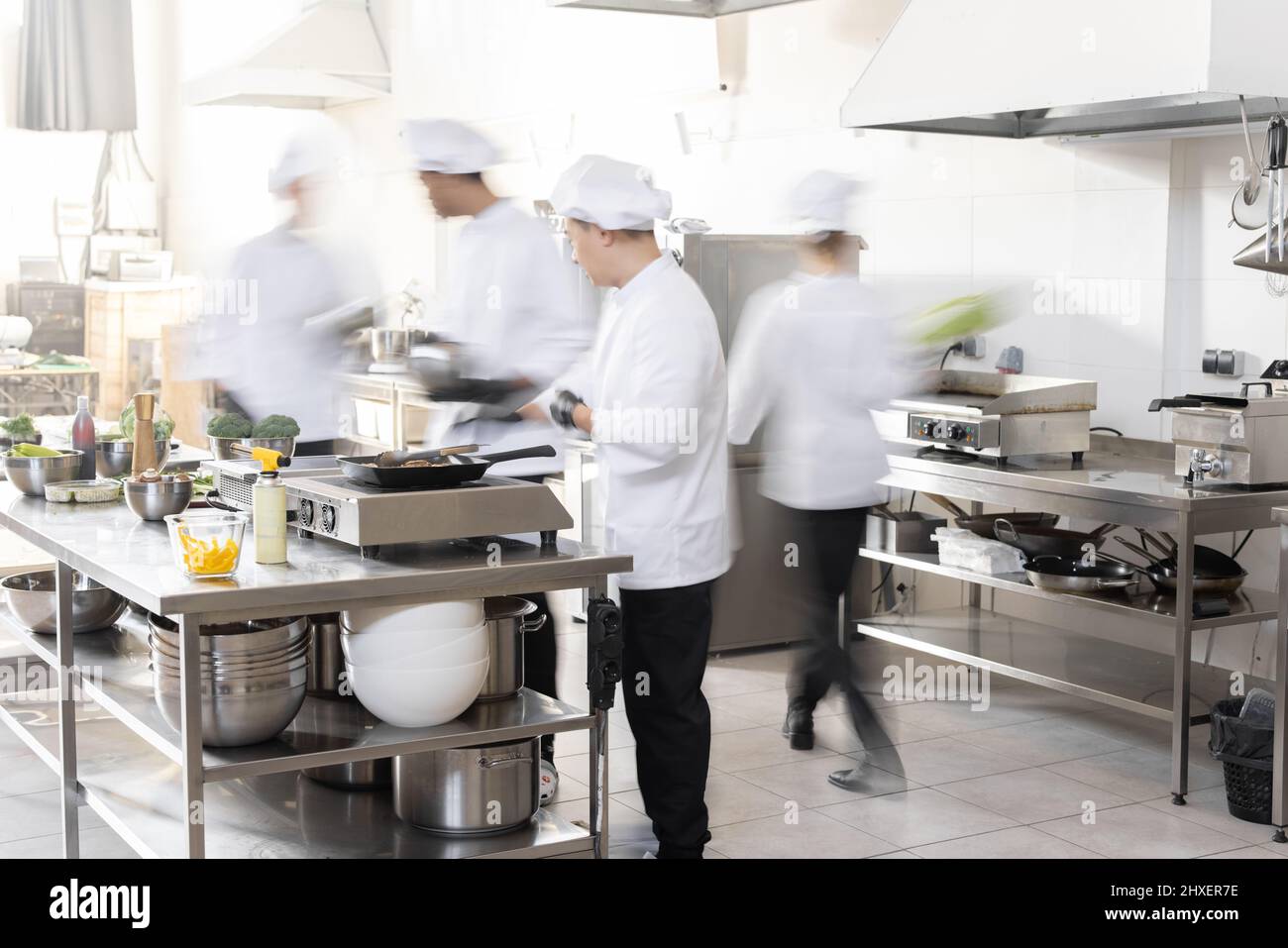 Chef cooks working in professional kitchen. Chefs hurry up, actively ...