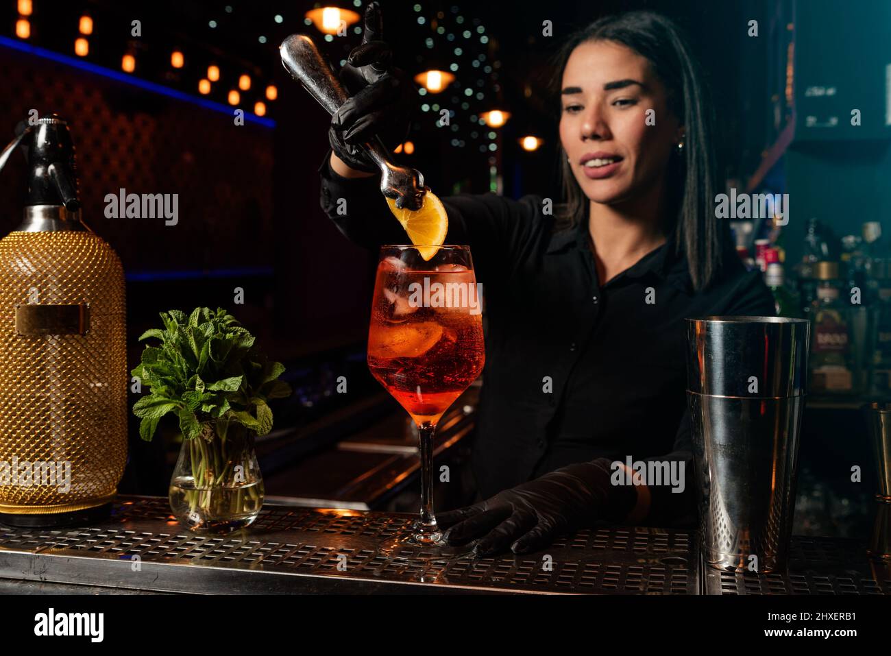 The young Latin brunette prepares a cocktail at the bar counter. job ...