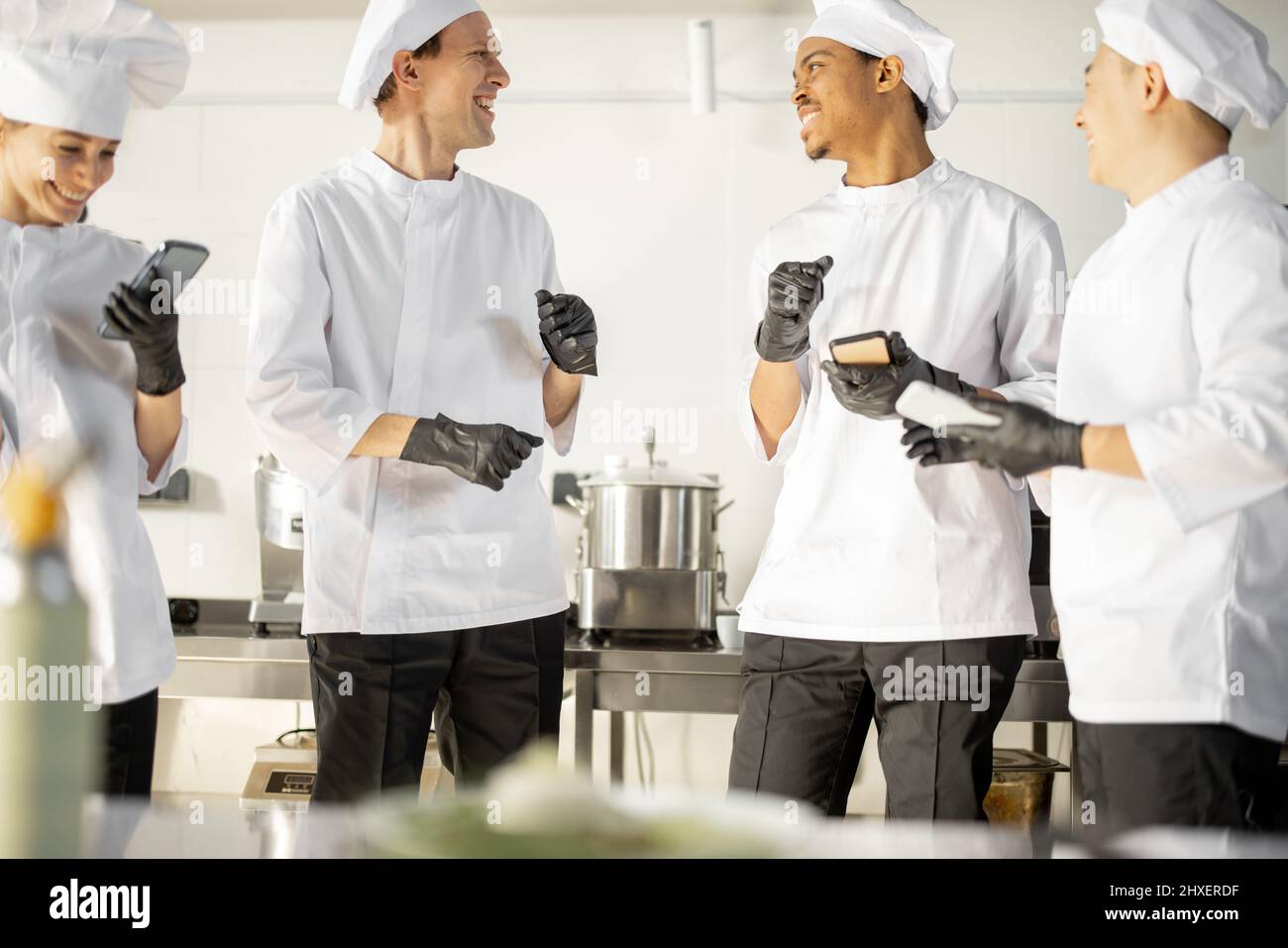 Team of multiracial cooks having conversation during a coffee break in ...