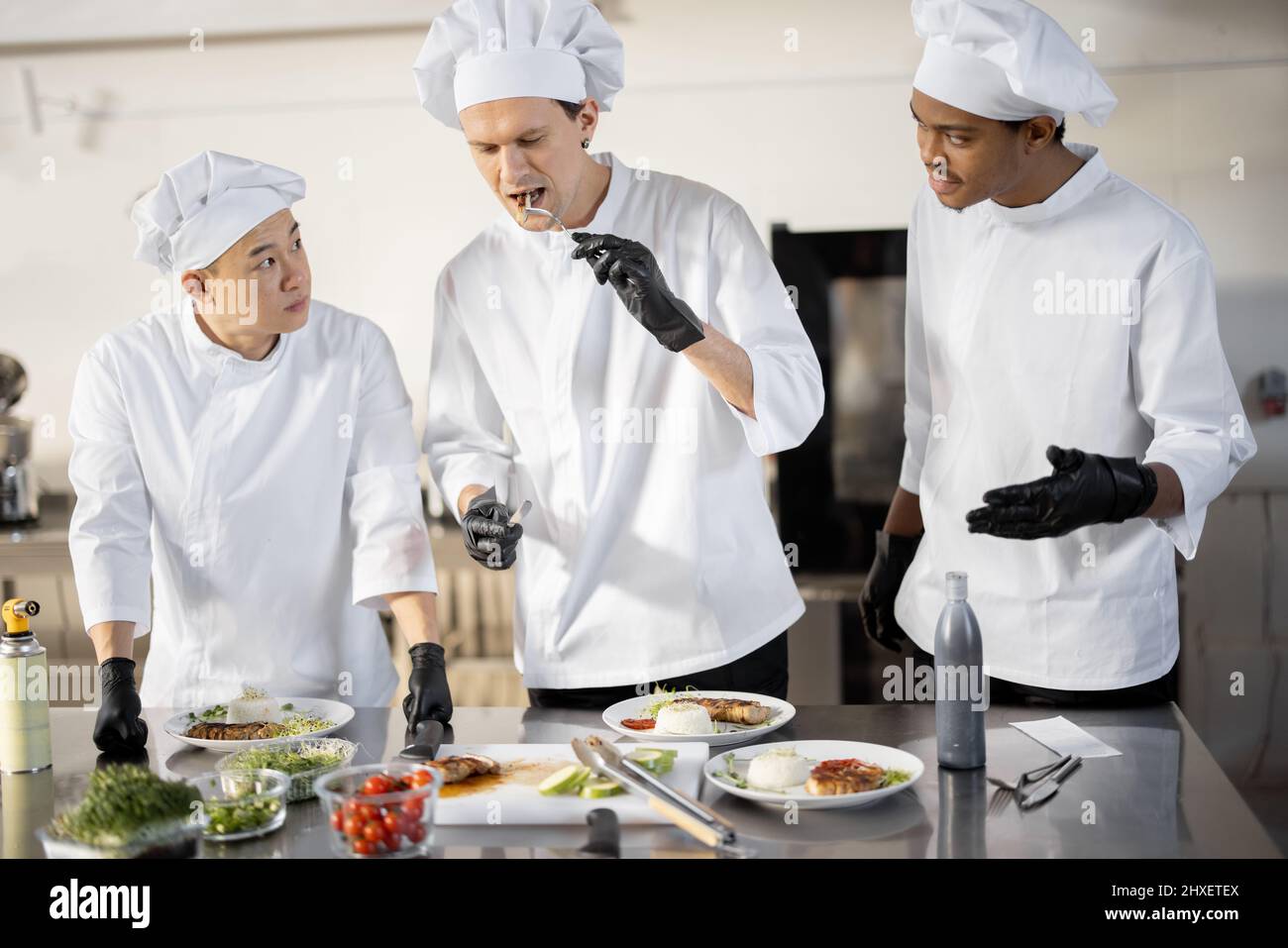 Three cooks with different nationalties tasting cooked meals, inventing ...