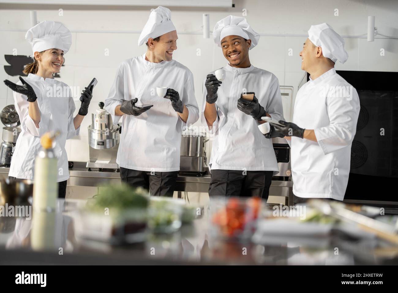 Team of multiracial cooks having conversation during a coffee break in ...