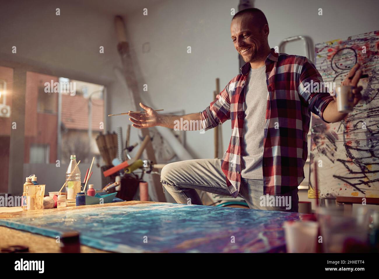 Smiling painter at workspace.Artist working on paint Stock Photo - Alamy
