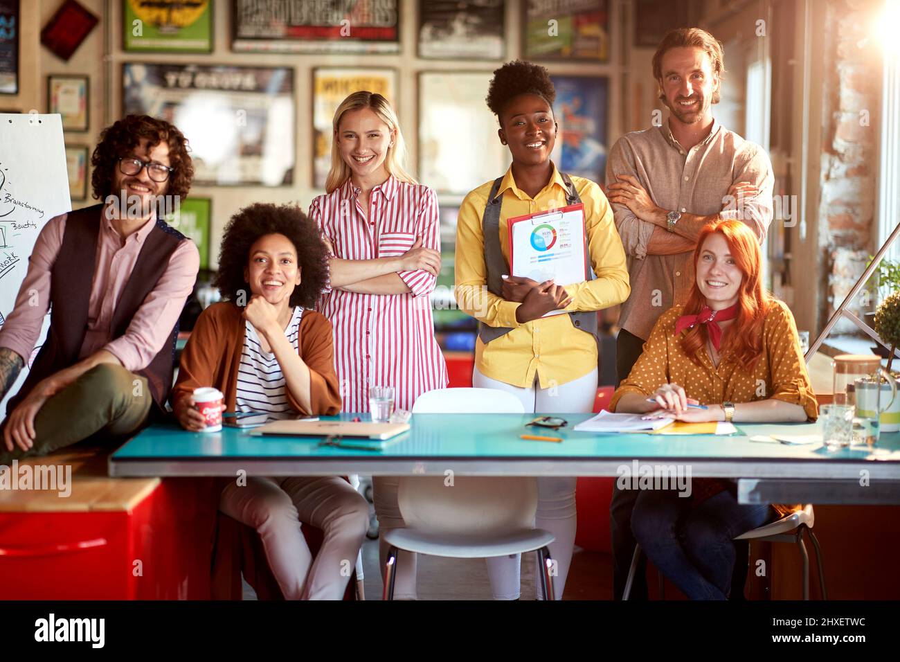 Group of young creative employees are posing for a photo while working ...