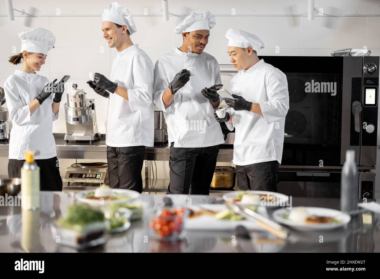 Team of multiracial cooks having conversation during a coffee break in ...