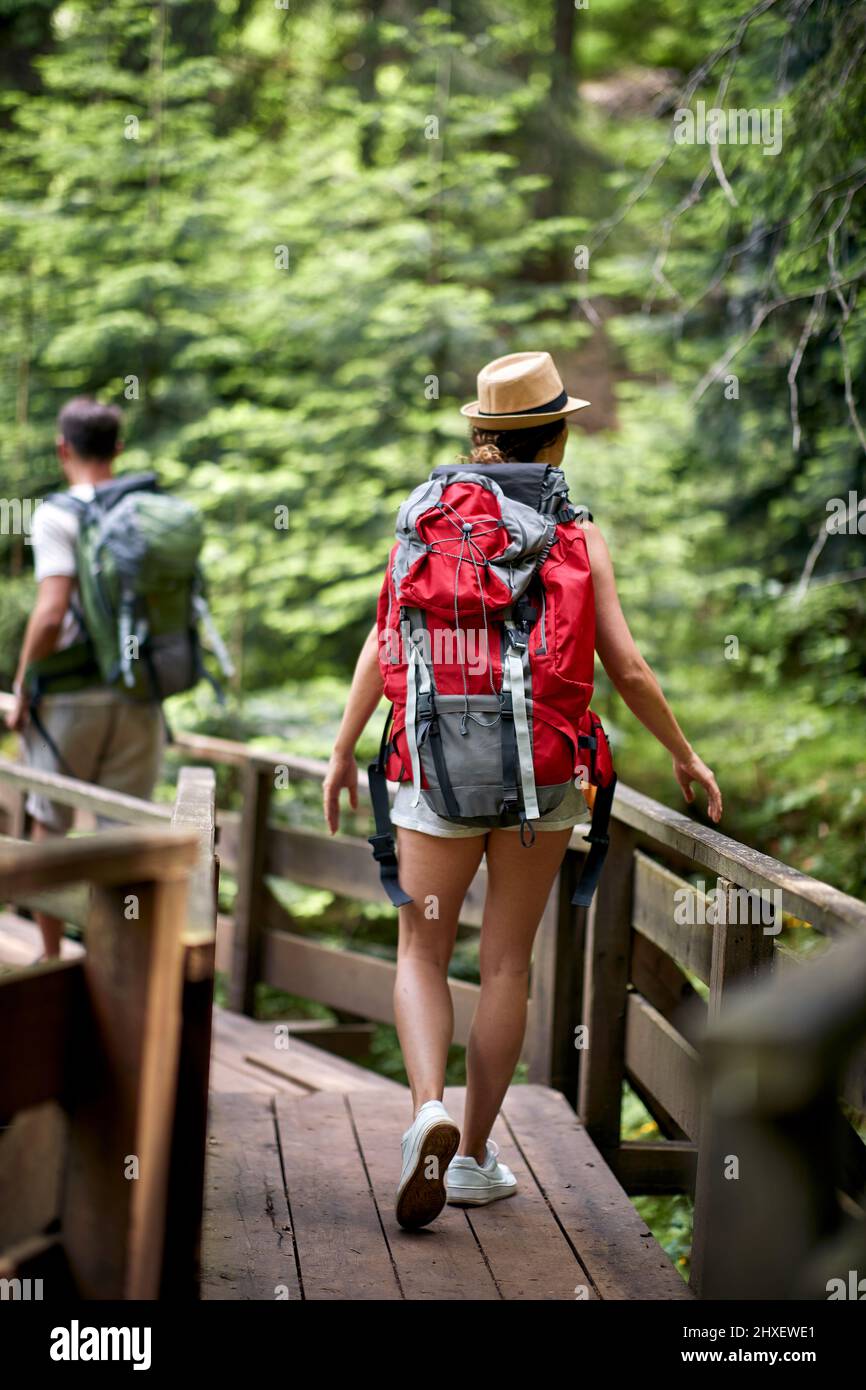 Tourists walking through bridge. Young backpacker couple. Hiking ...