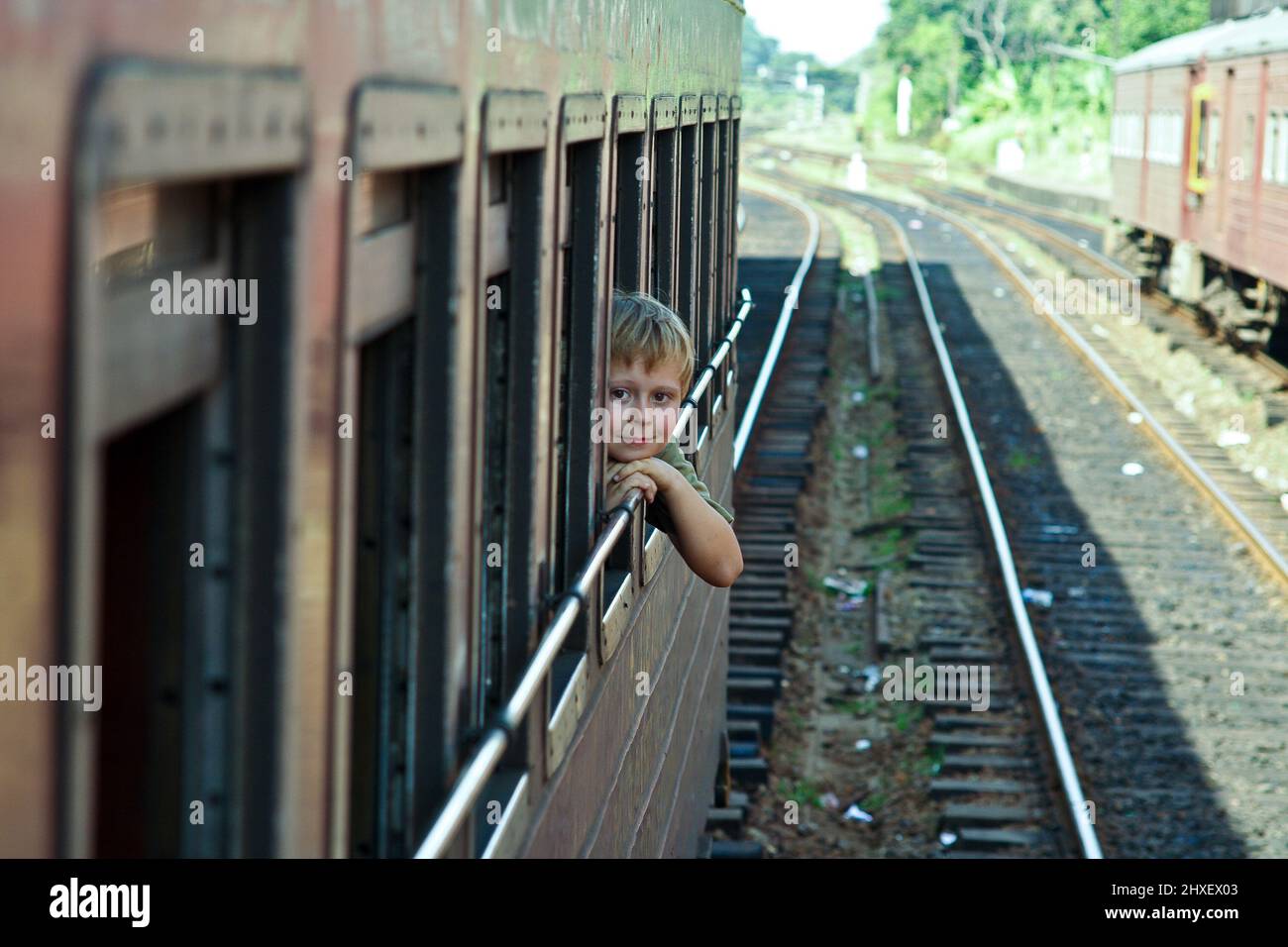 boy is looking out of the window of a train Stock Photo - Alamy