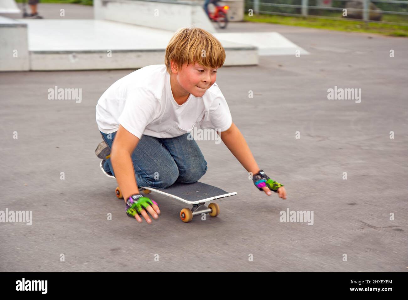 boy riding skate board while sitting Stock Photo - Alamy