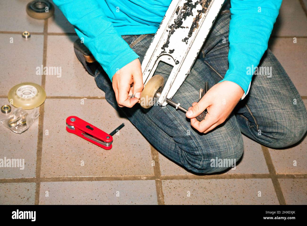 boy is repairing the weels at his scooter Stock Photo - Alamy