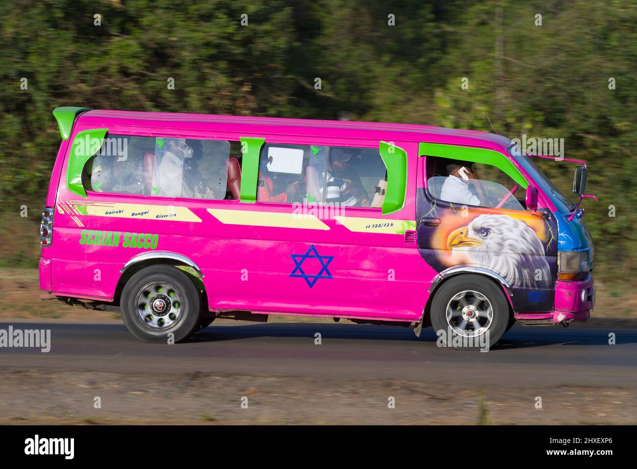 Bus with customised paintwork driving along Magadi Road, Langata. Many ...