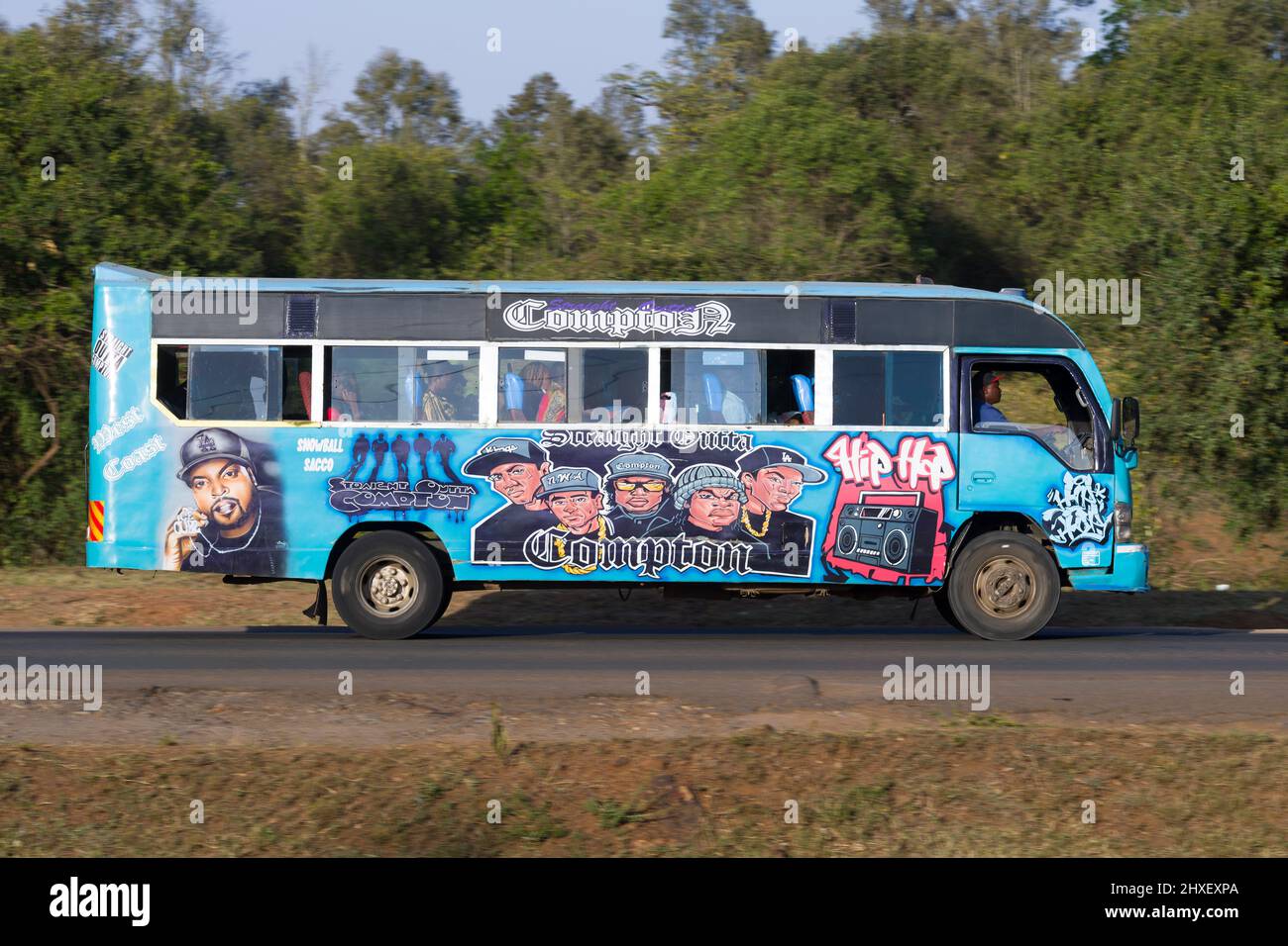 Bus with customised paintwork driving along Magadi Road, Langata. Many ...