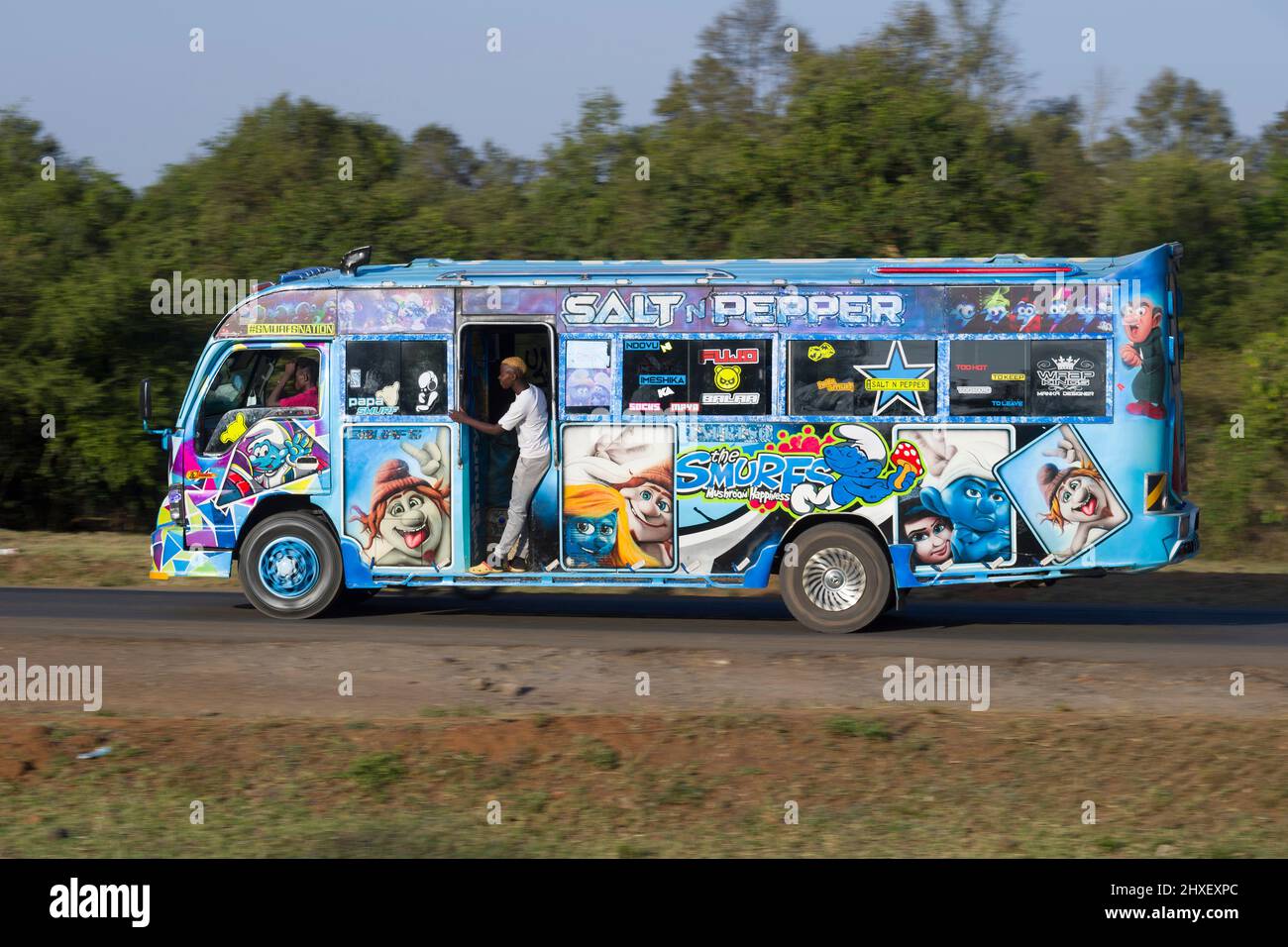 Bus with customised paintwork driving along Magadi Road, Langata. Many ...