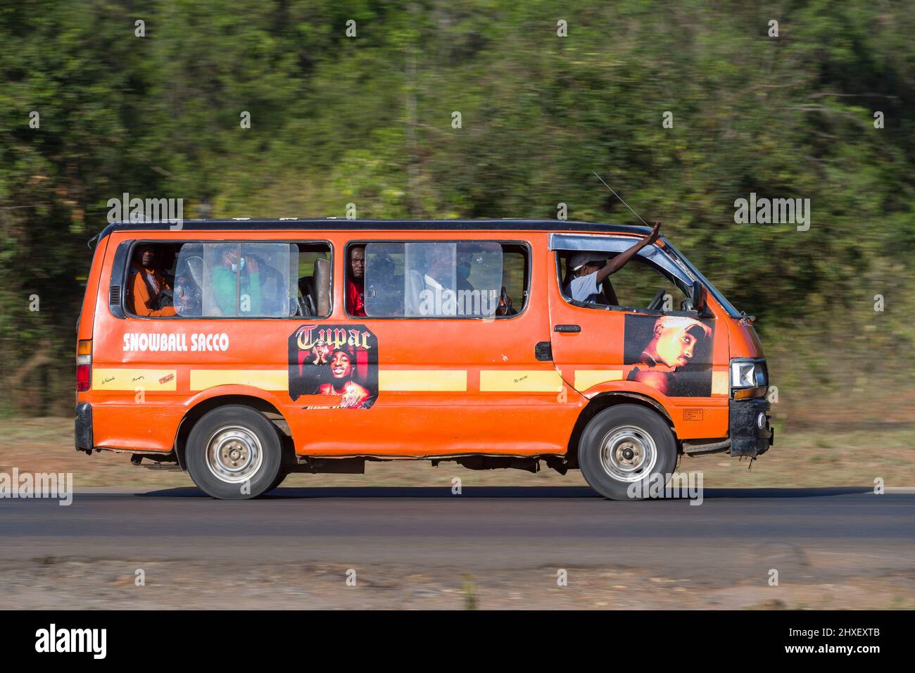 Bus with customised paintwork driving along Magadi Road, Langata. Many ...