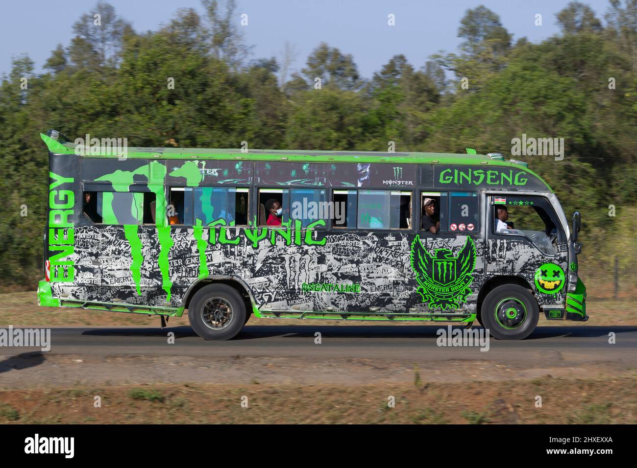 Bus with customised paintwork driving along Magadi Road, Langata. Many ...