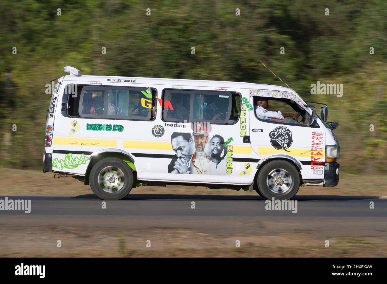 Bus with customised paintwork driving along Magadi Road, Langata. Many ...