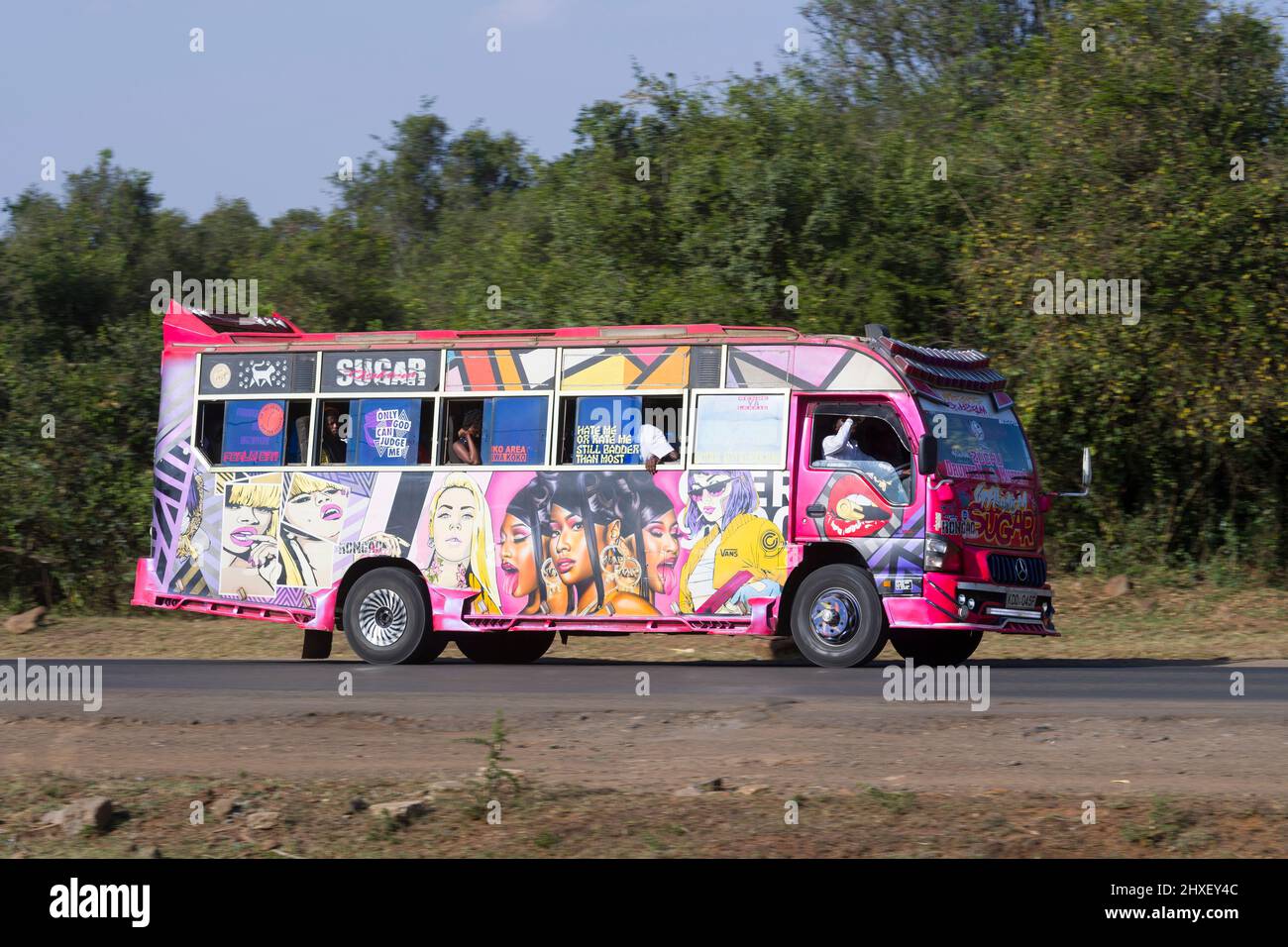 Bus with customised paintwork driving along Magadi Road, Langata. Many ...
