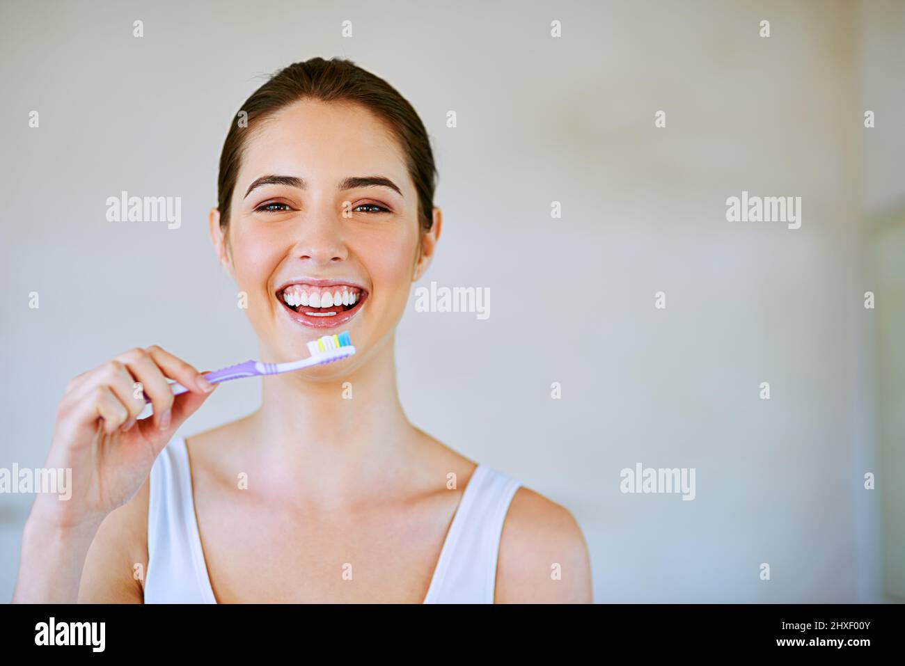 I brush because I love my teeth. Cropped shot of a young woman brushing ...