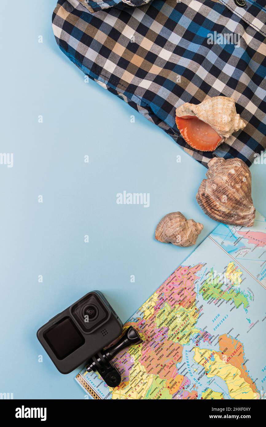 Travel fees, an action camera world map and a plaid shirt on a blue ...