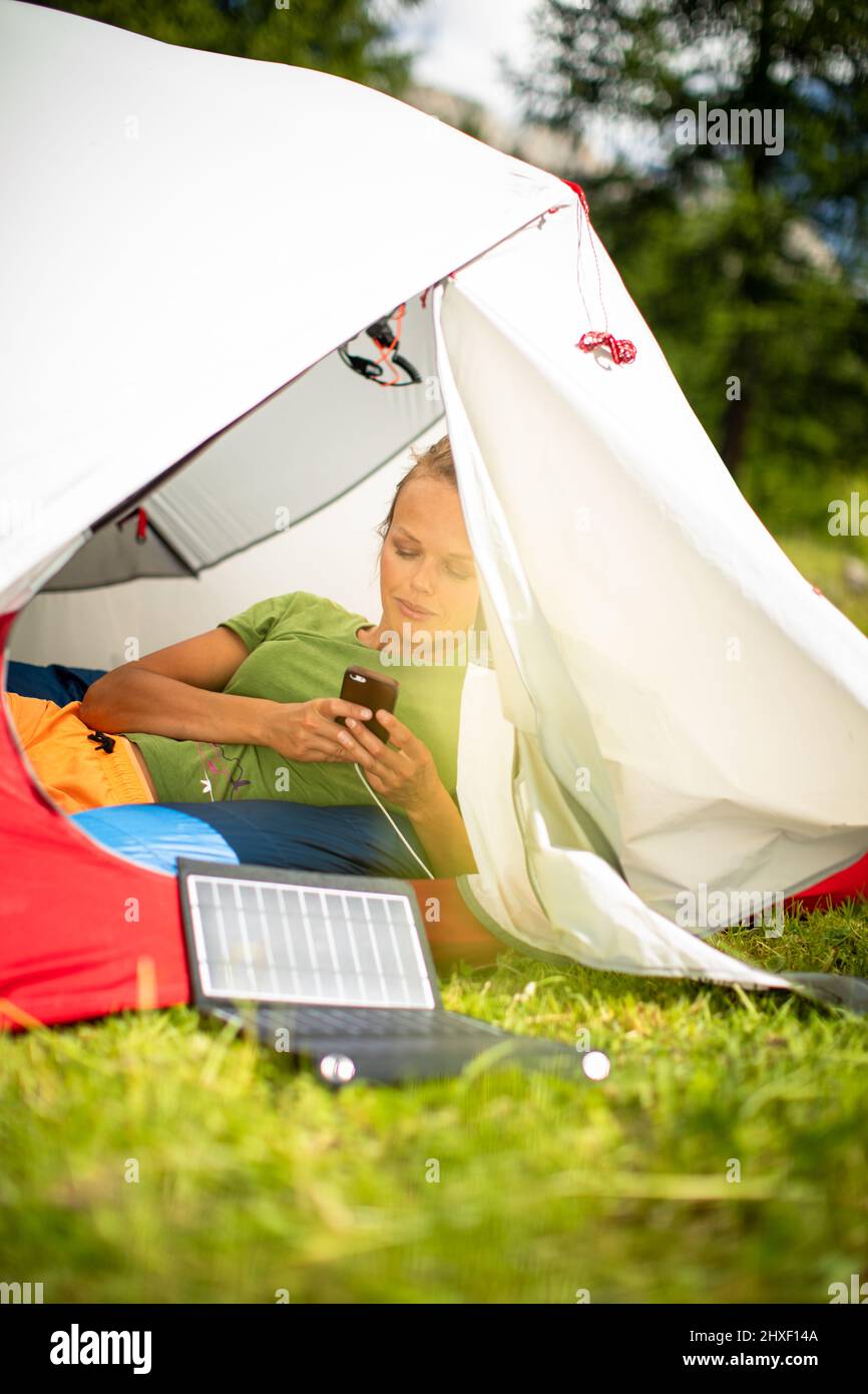 Cell phone charging with a solar charger in a tent during an outdoor ...