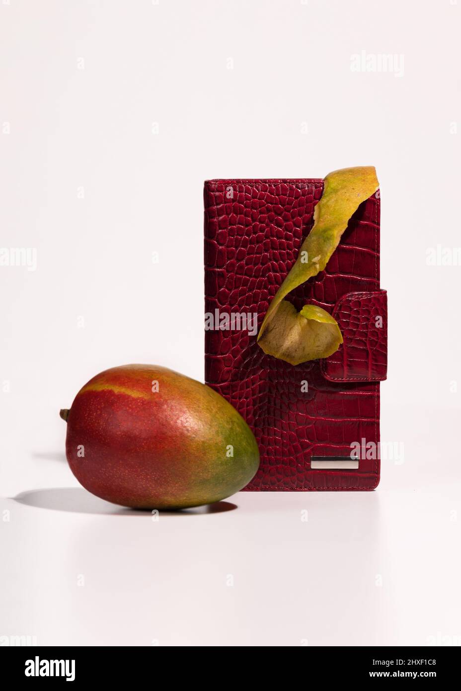 Red purse and mango fruit waste on white background. Vegan ...