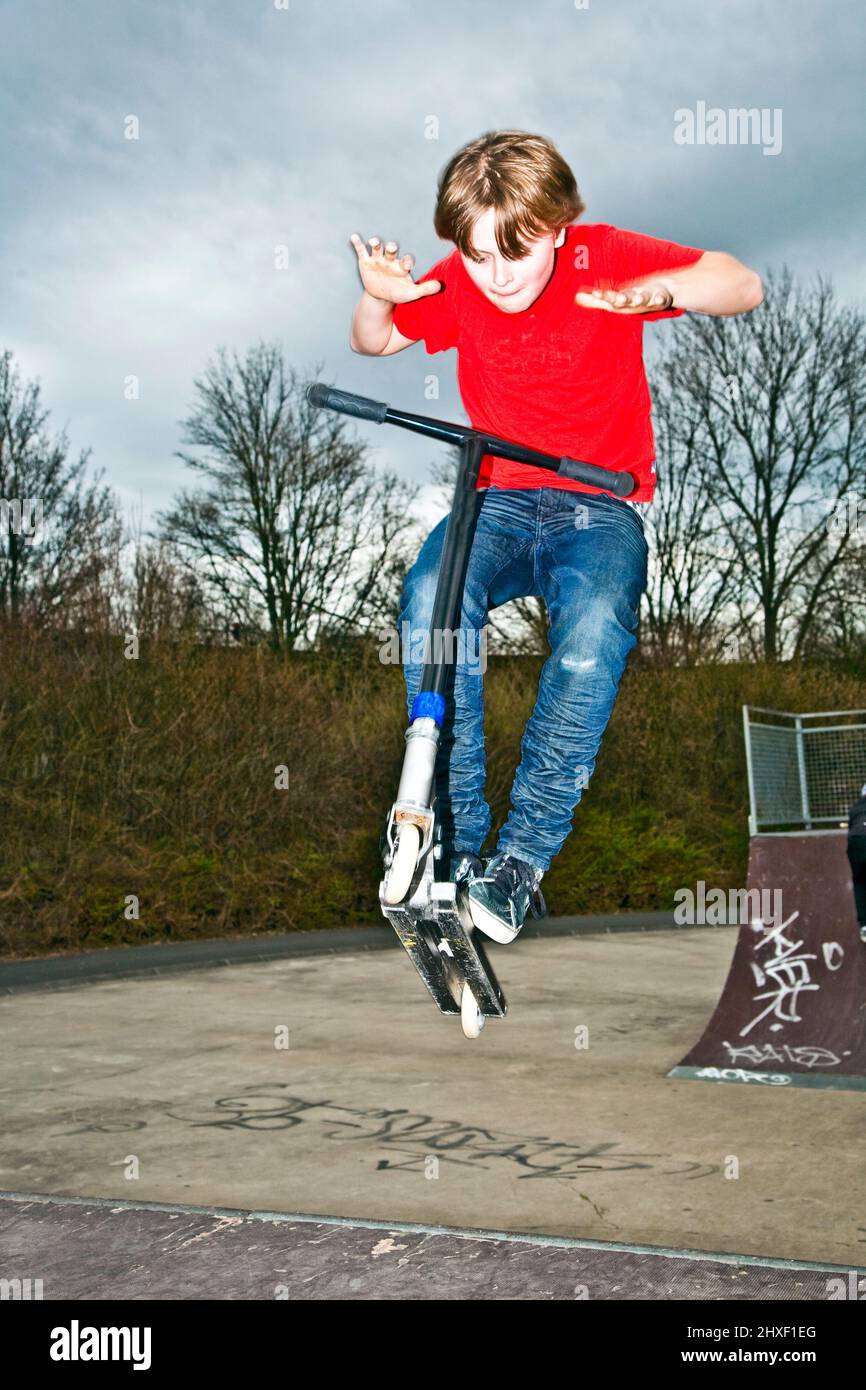 Boy riding a scooter going airborne at a scooter park Stock Photo - Alamy