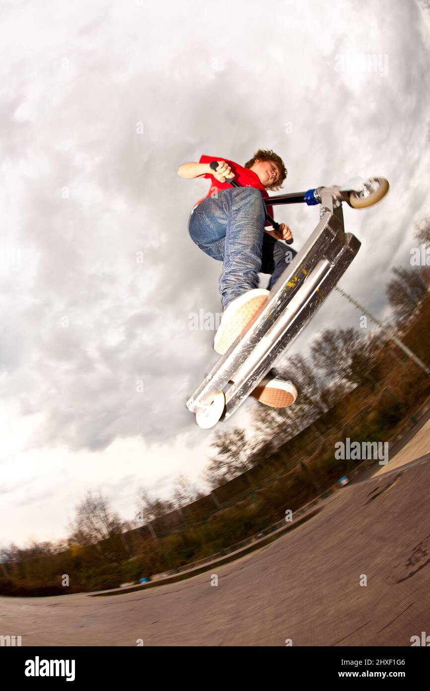 Boy riding a scooter gone airborne on a scooter park Stock Photo - Alamy