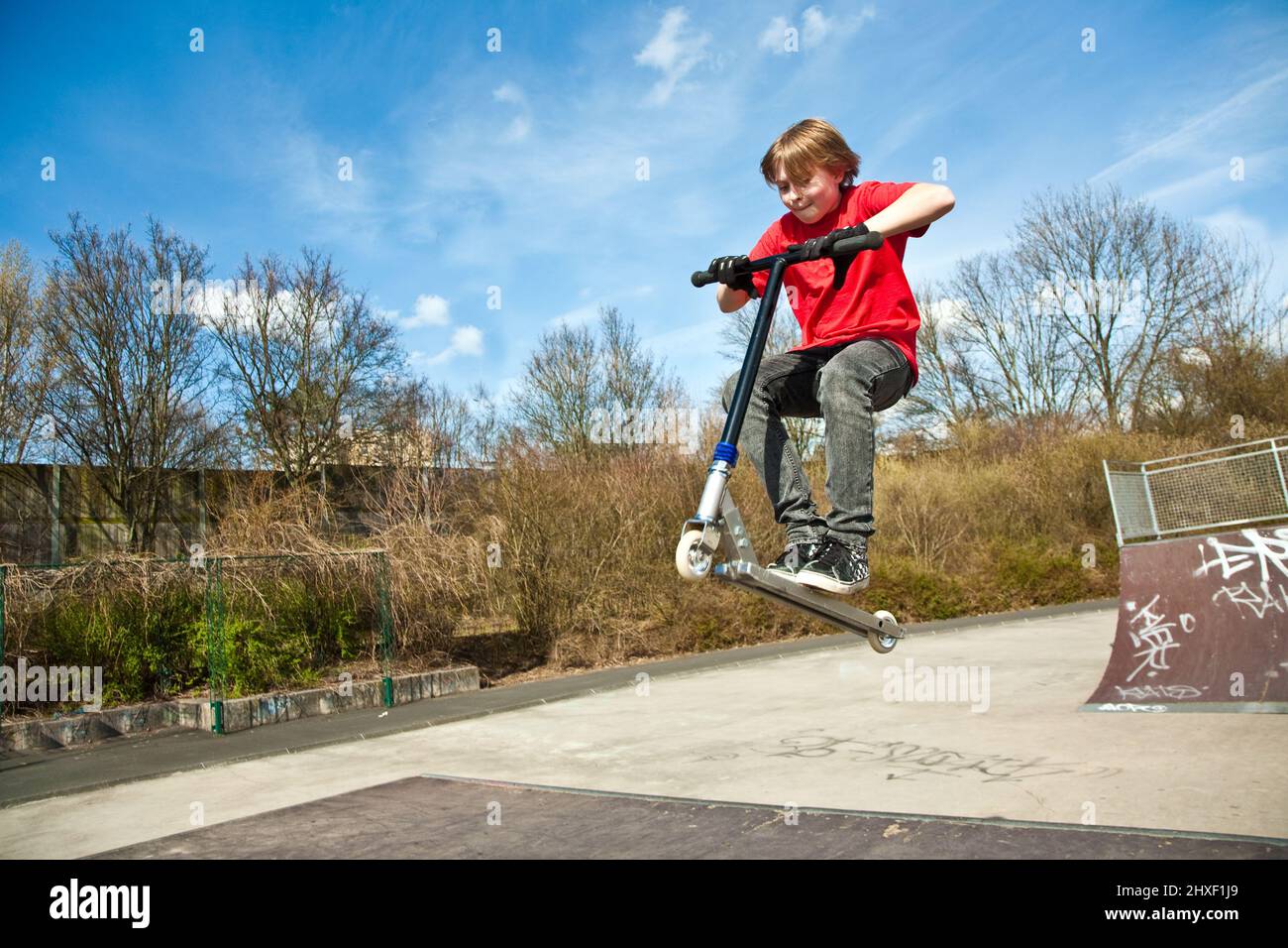 boy jumping with a scooter over a funbox Stock Photo - Alamy