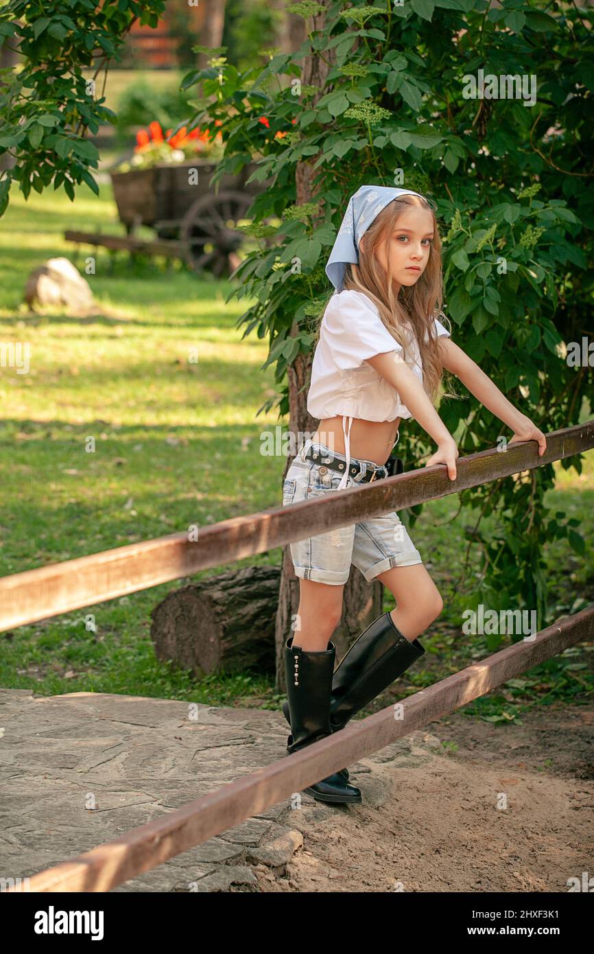 Teenage girl posing near iron fencing in green park of rural mansion ...