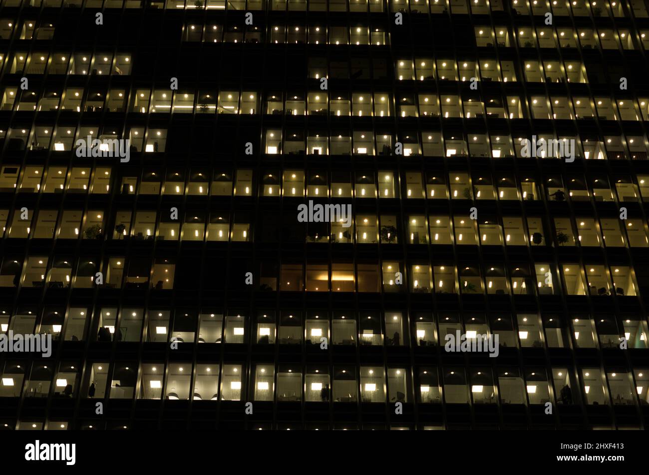 Multiple illuminated windows in an office building at night Stock Photo ...