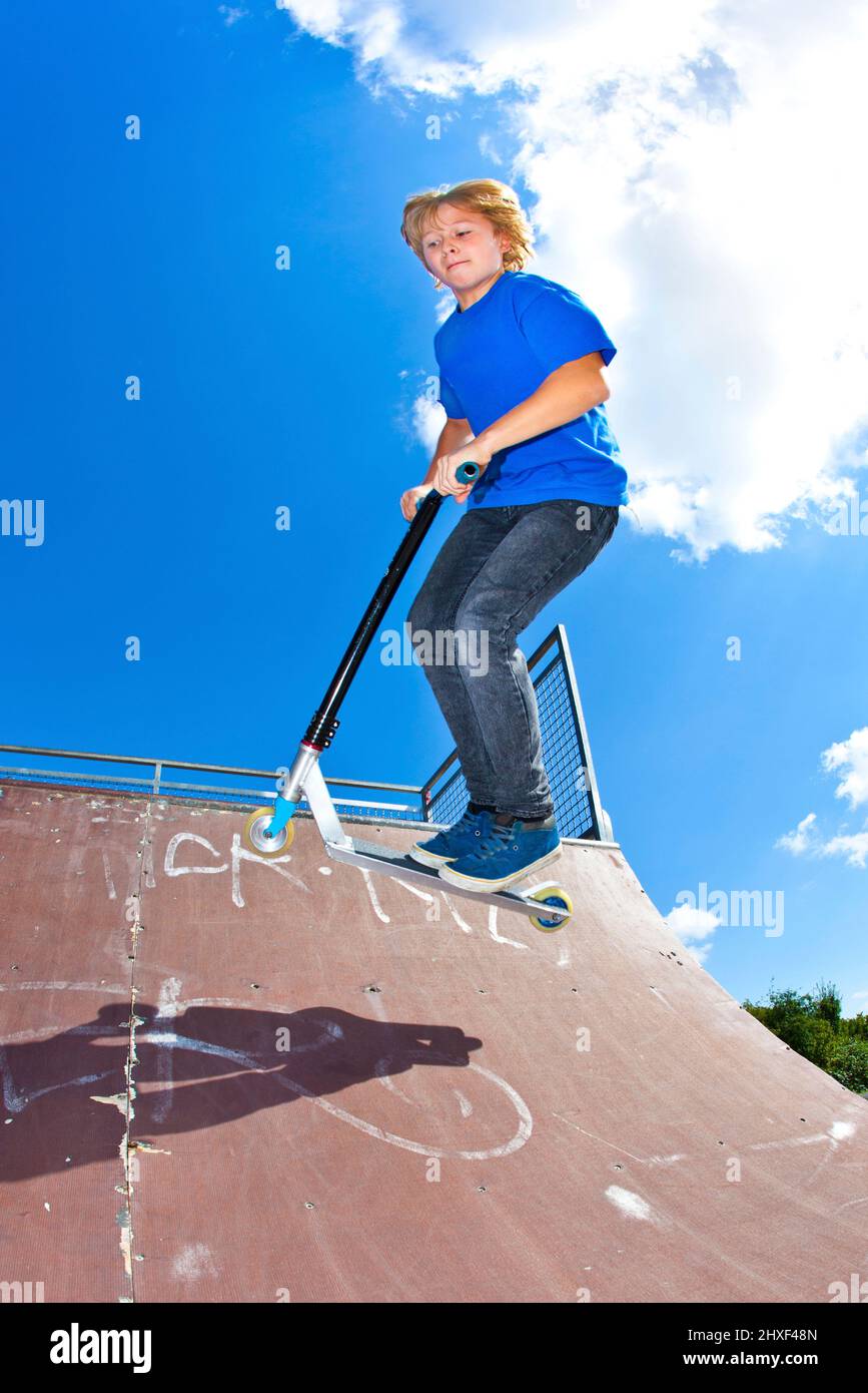 boy jumping with his scooter over a ramp Stock Photo - Alamy