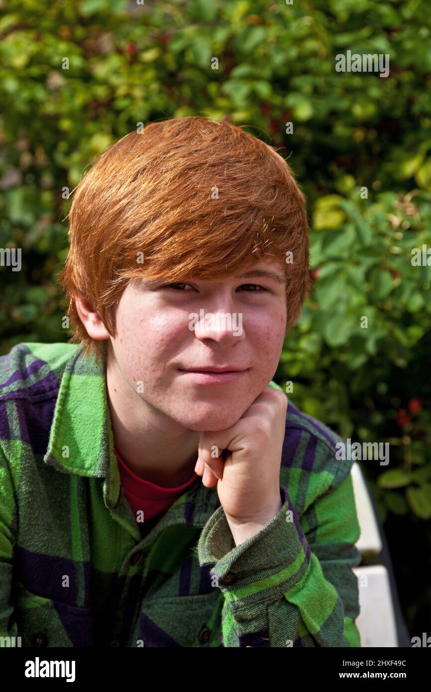 boy sitting on a bench in a park Stock Photo - Alamy
