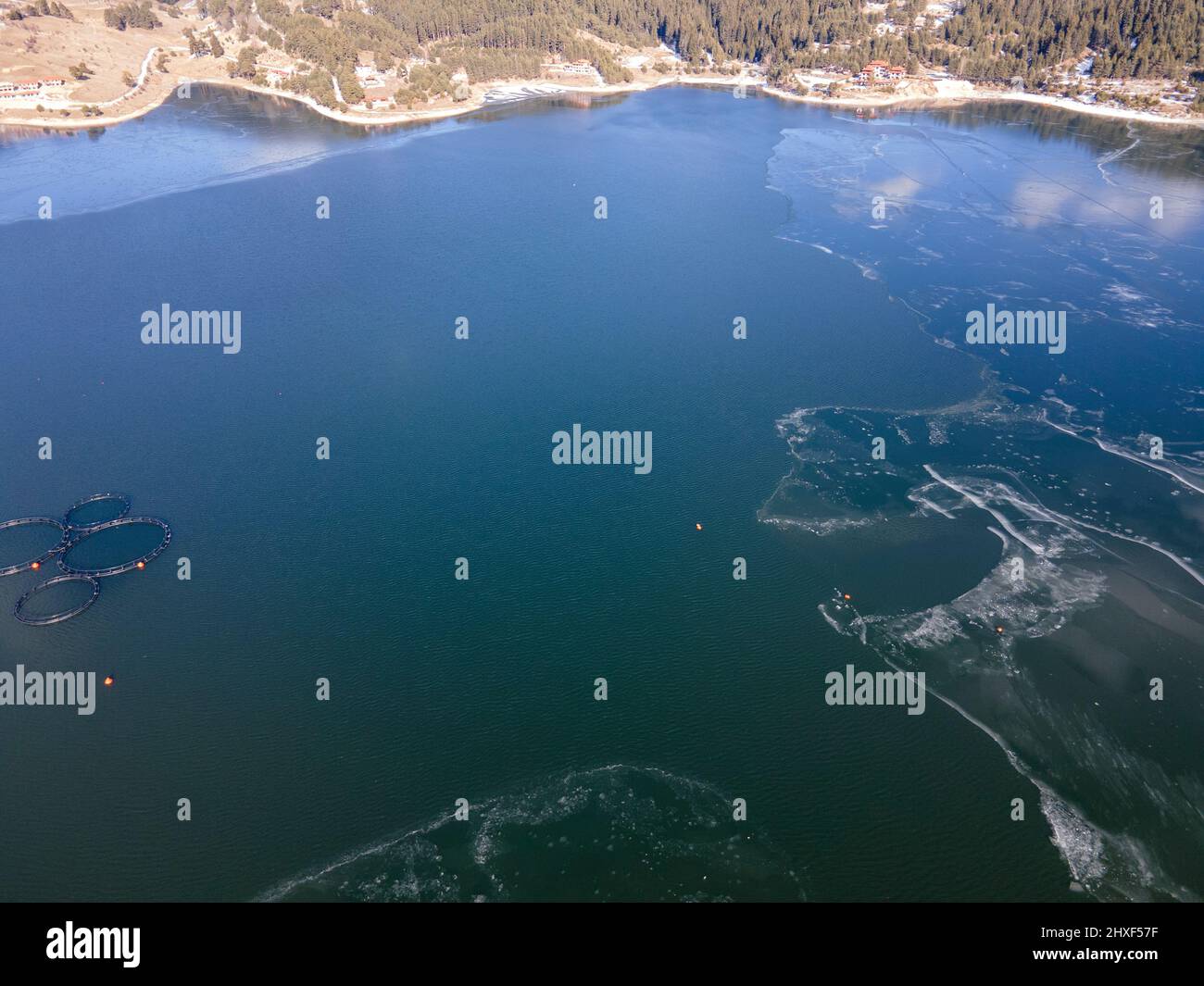 Aerial winter view of Dospat Reservoir covered with ice, Smolyan Region ...
