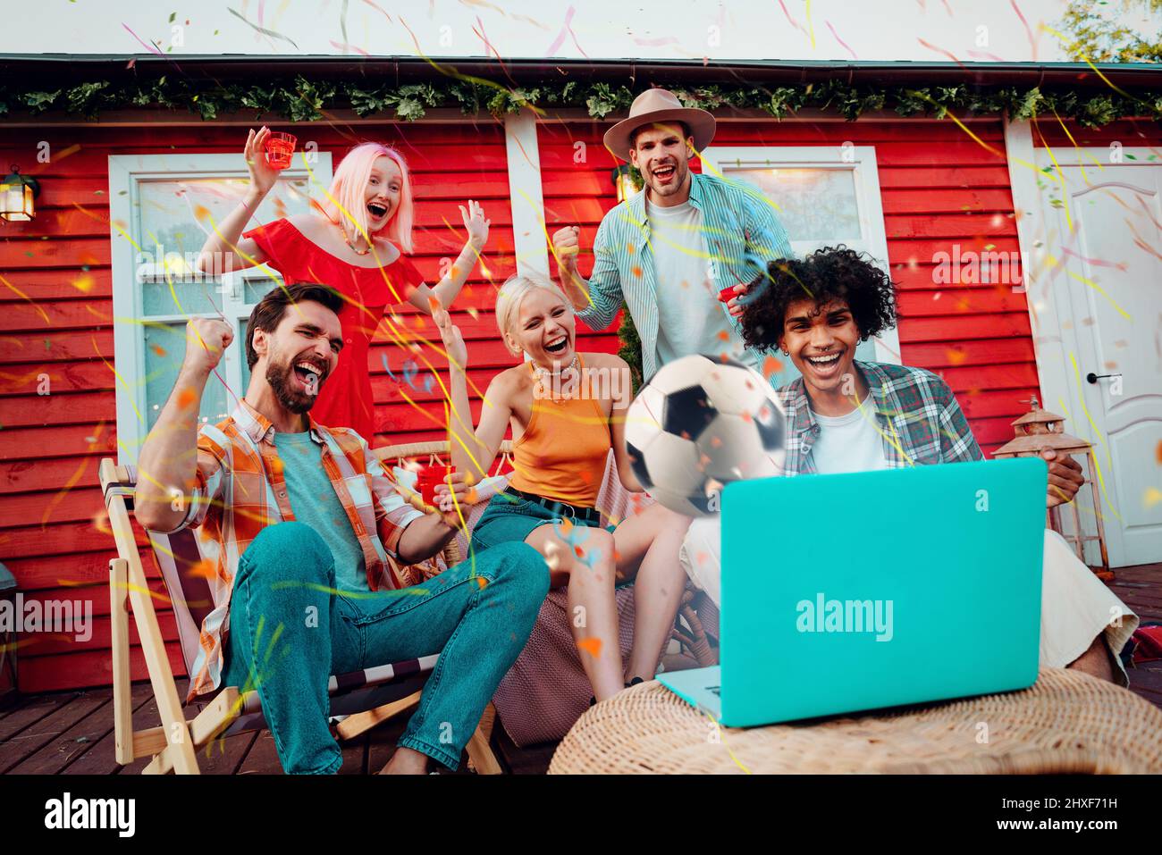 Happy friends of football fans watching soccer on laptop and ...